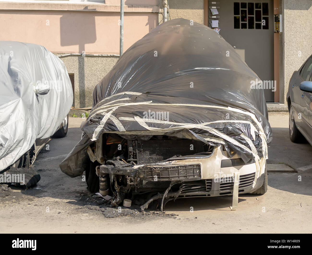 Car damaged by fire near residential building. Partially burnt cars ...