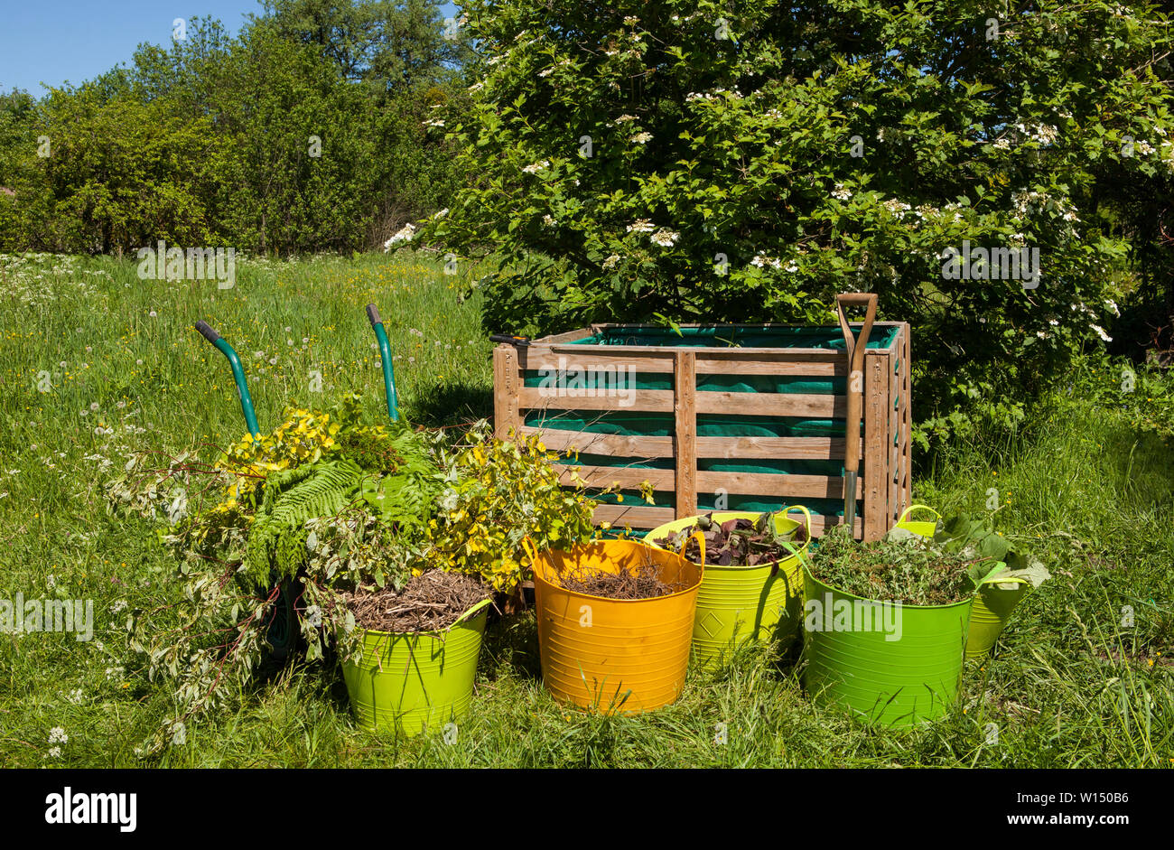 Compost bin and mulch in a summer garden Stock Photo - Alamy
