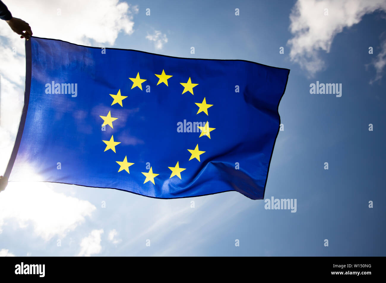 Waving European Union flag on blue sky Stock Photo - Alamy
