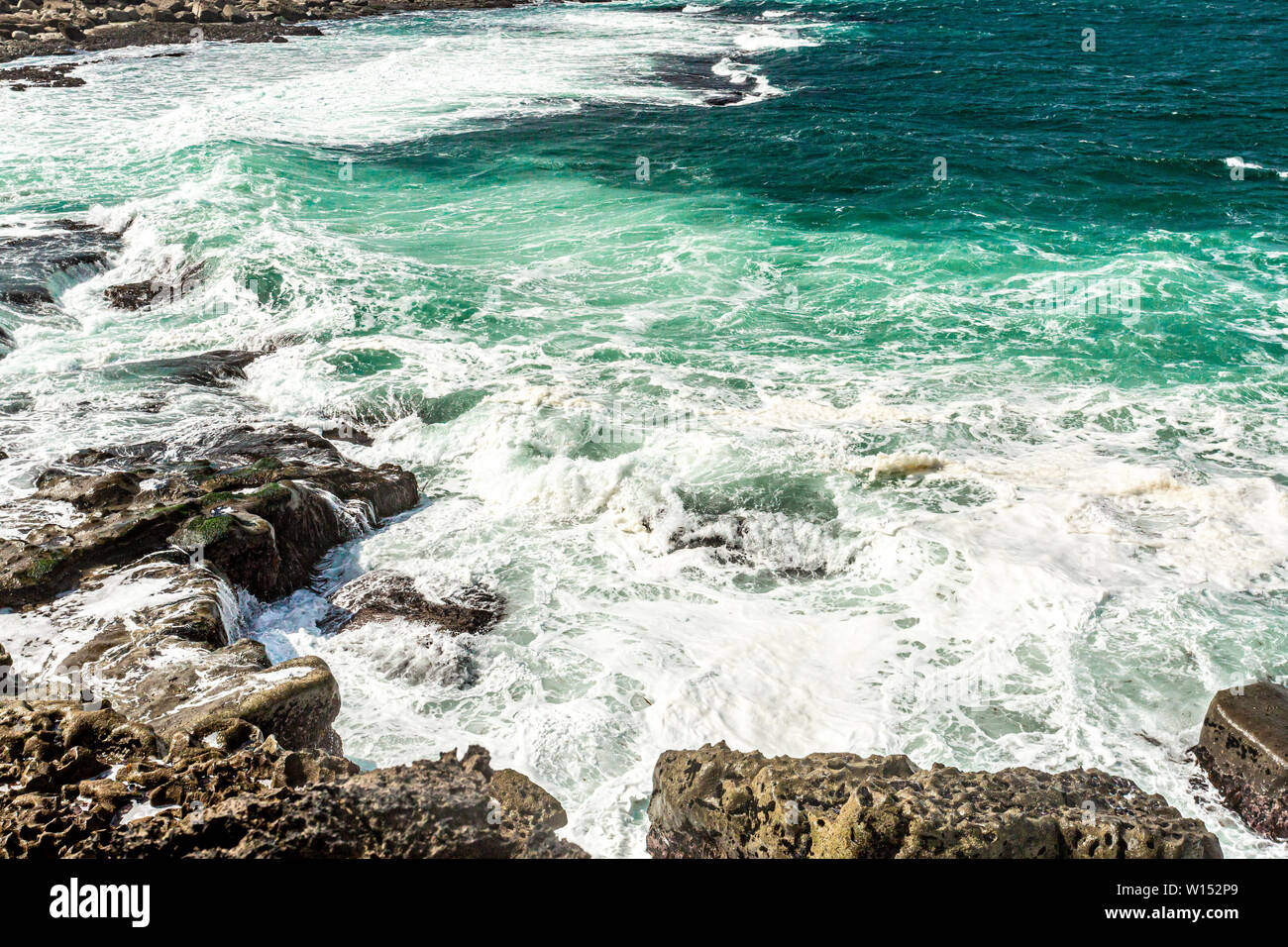 Waves crashing on limestone rocks at Bothar Beach nA hAillite, geoparks ...