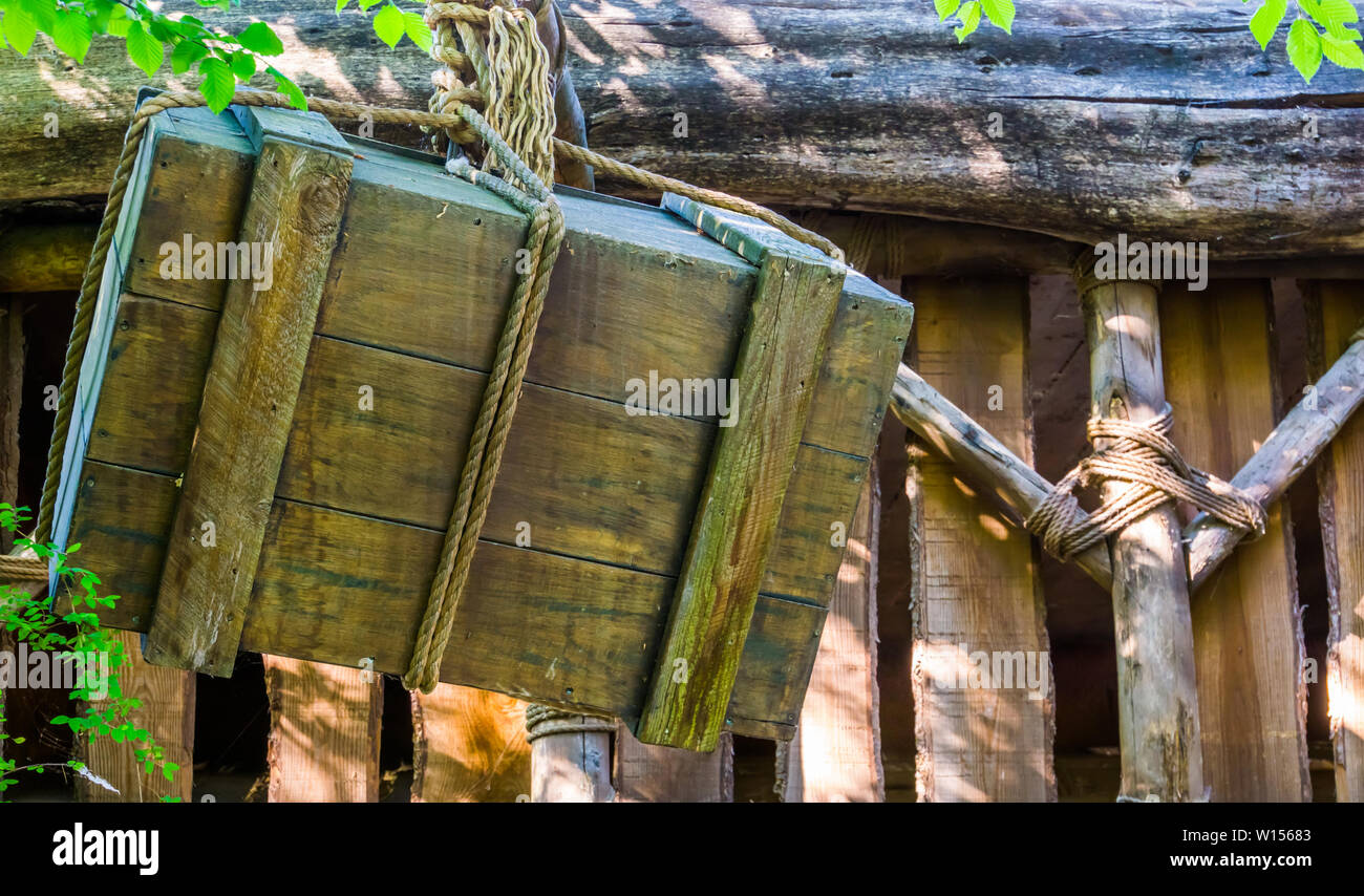 Old weathered wooden box hanging on a rope, medieval lifting methods ...