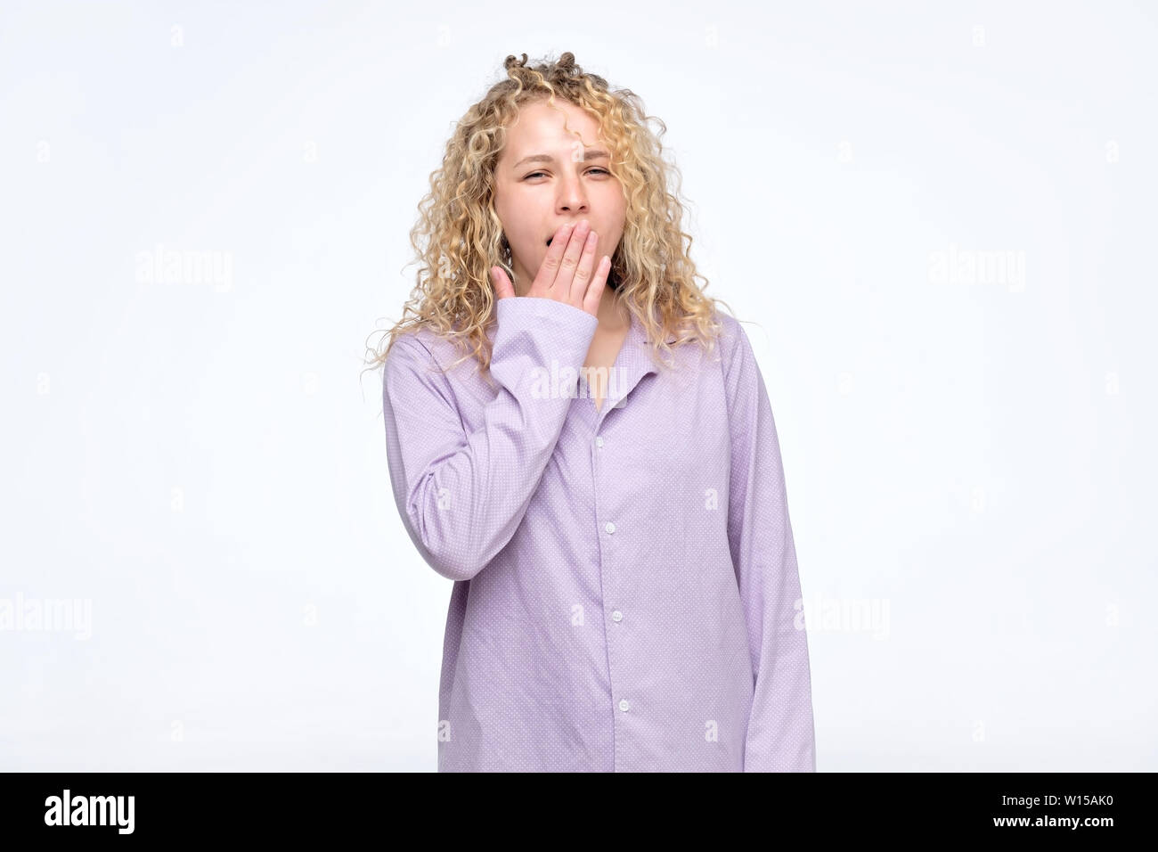 Pretty curly tired girl yawning. I do not get enough sleep Stock Photo ...