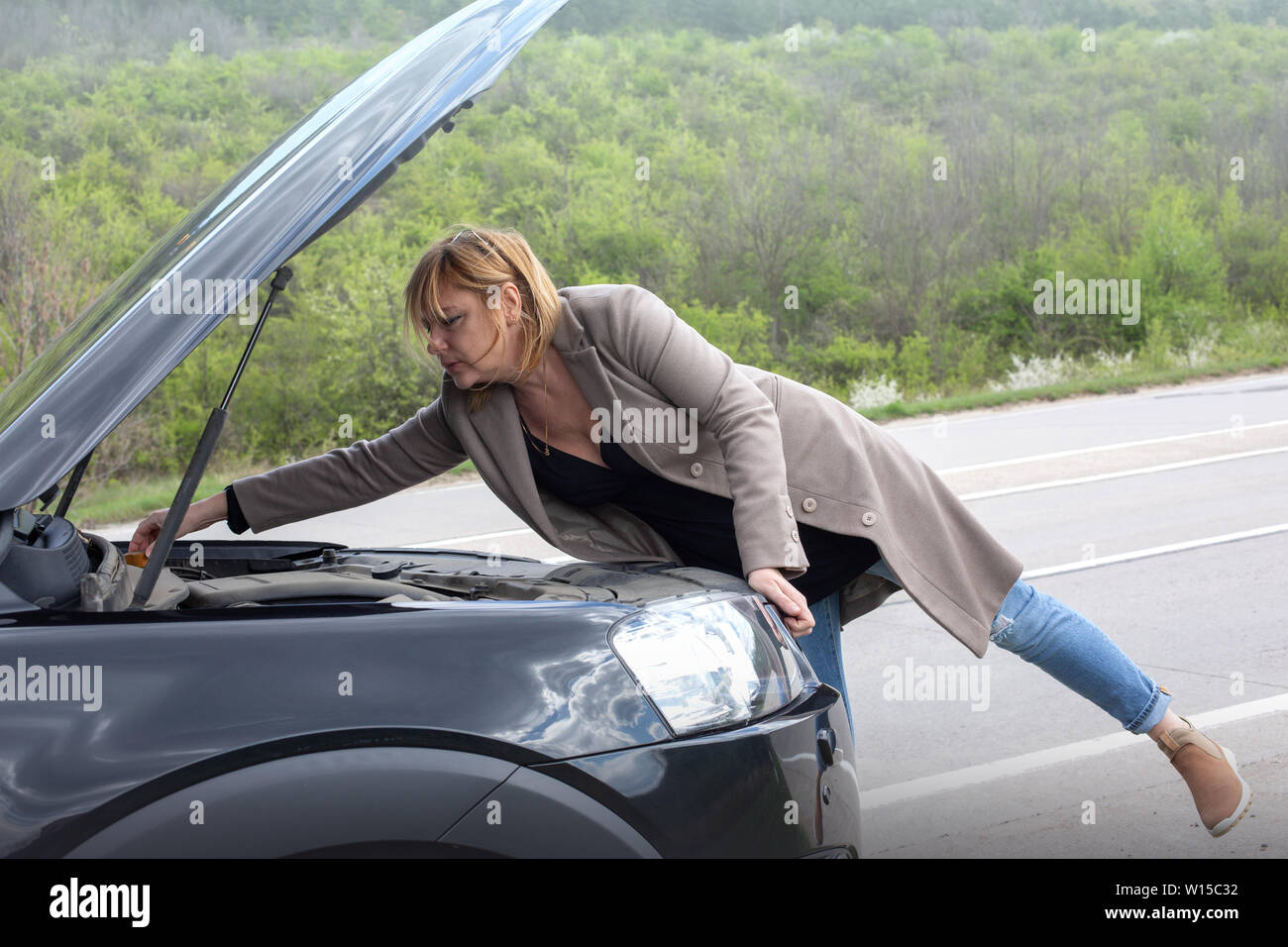 Accident and breakdowns with auto concept. Blonde woman and broken down ...