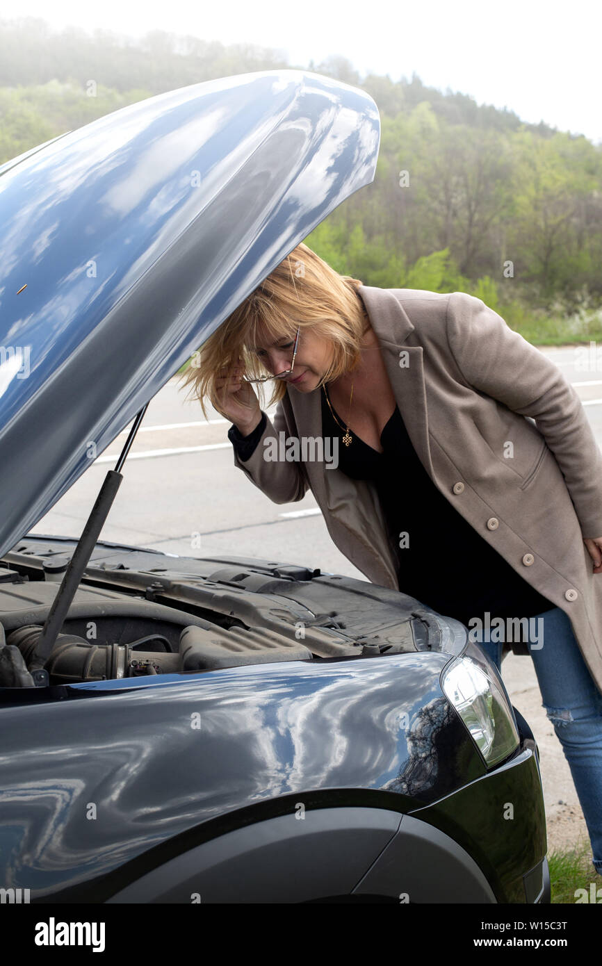 Accident and breakdowns with auto concept. Blonde woman and broken down ...
