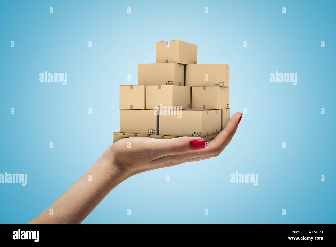 Side closeup of woman's hand holding stack of small carboard boxes on ...