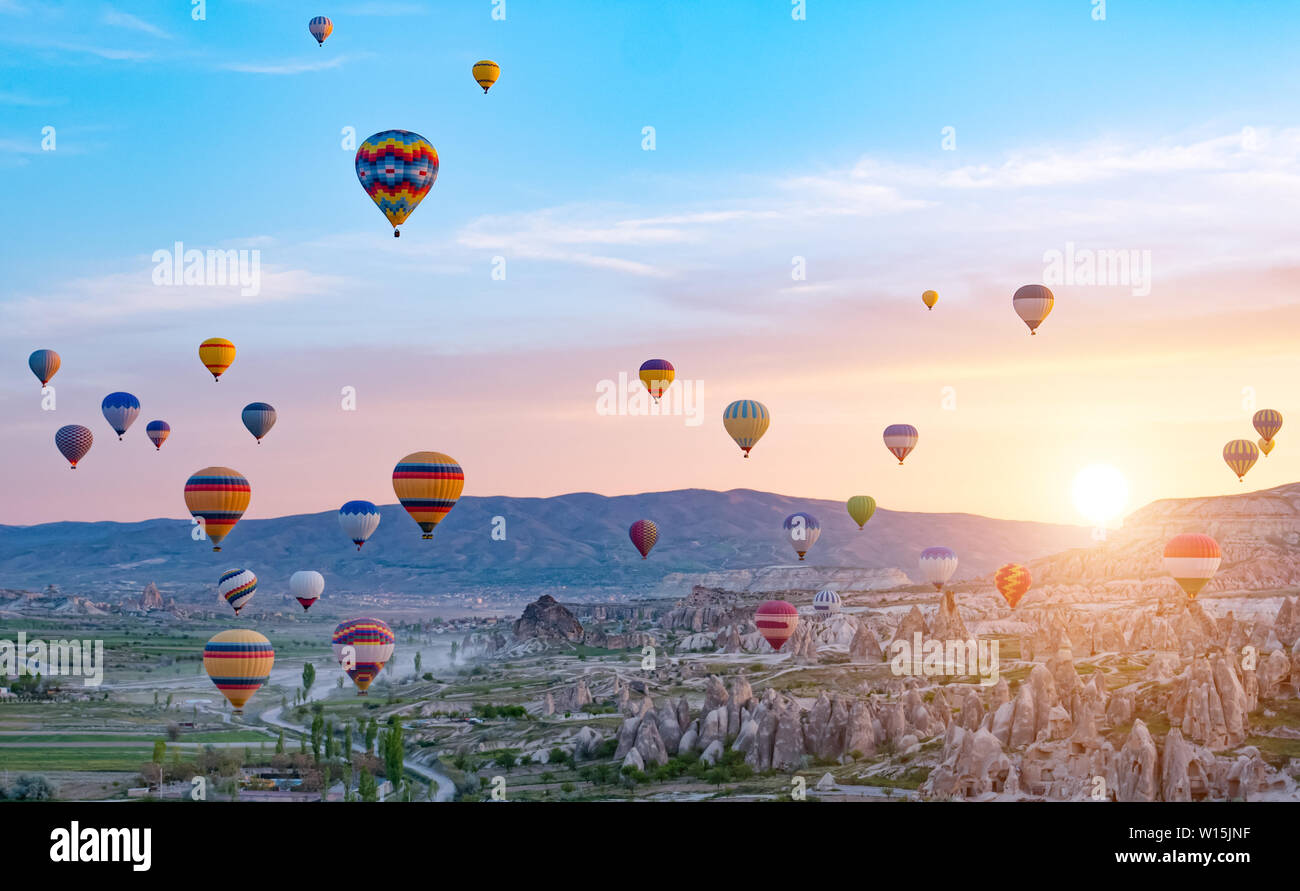 Colorful hot air balloons flying over rock landscape at Cappadocia ...