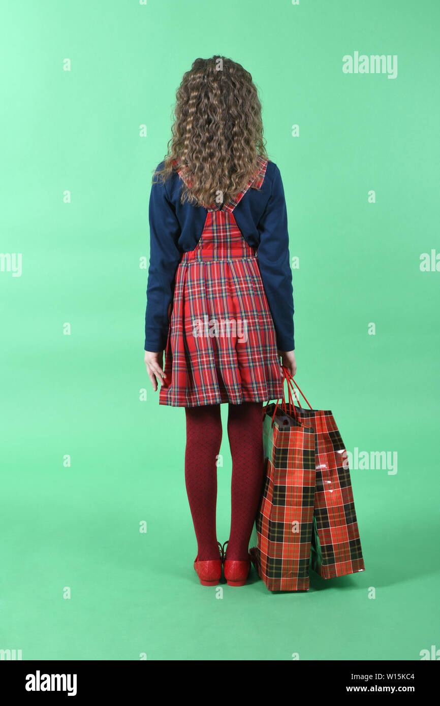 Child with a red packet isolated on green background. Little beauty ...