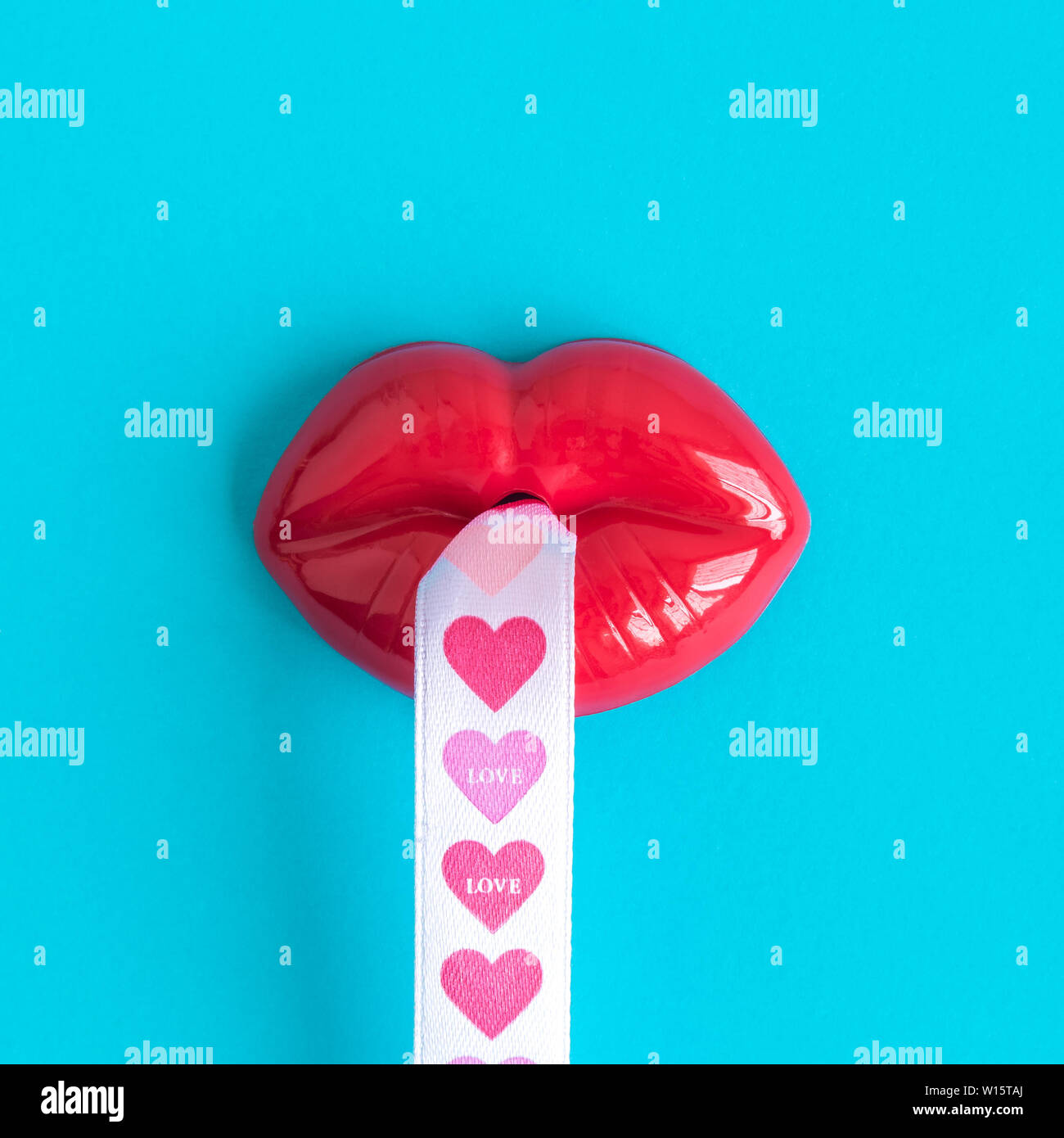 Plastic red lips and heart design ribbon. Sending kisses and love ...