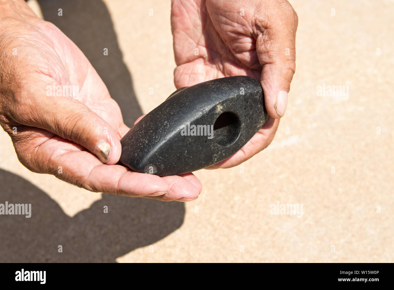 An old stone Hammer an elder man holds in his hands. Archaeology. Study ...