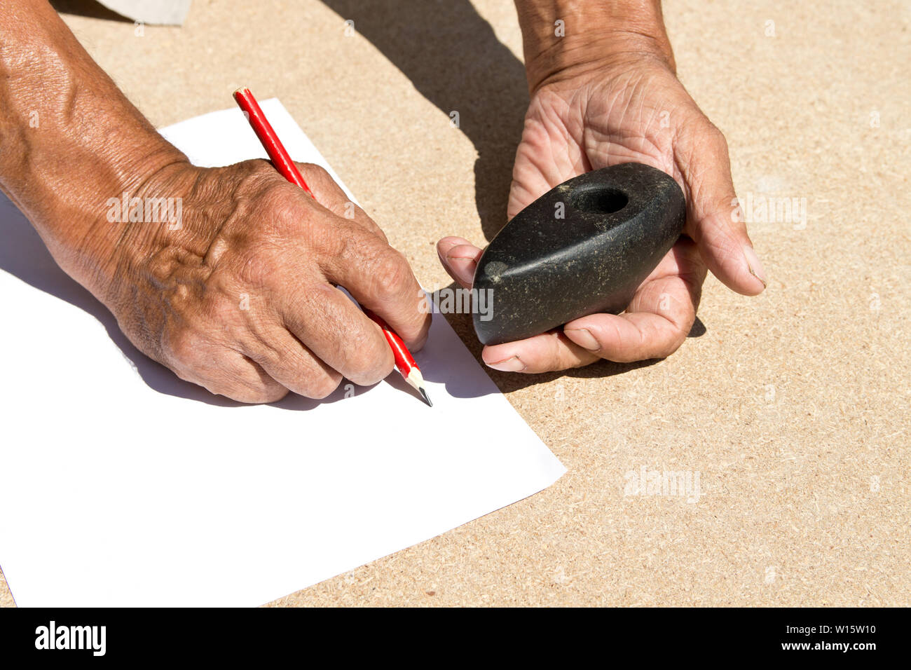 An old stone Hammer an elder man holds in his hands. Archaeology. Study ...