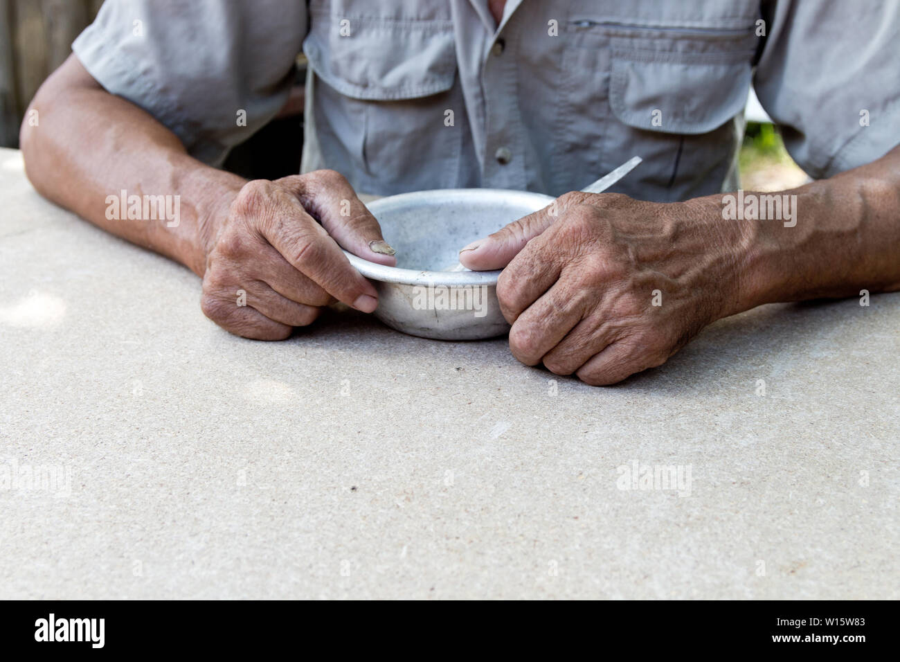 Hungry. Poor old man's hands an empty bowl. Selective focus. Poverty in ...
