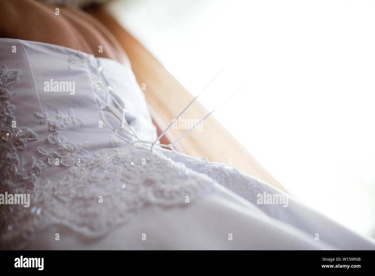 Bride from the back. Lacing the wedding dress Stock Photo - Alamy