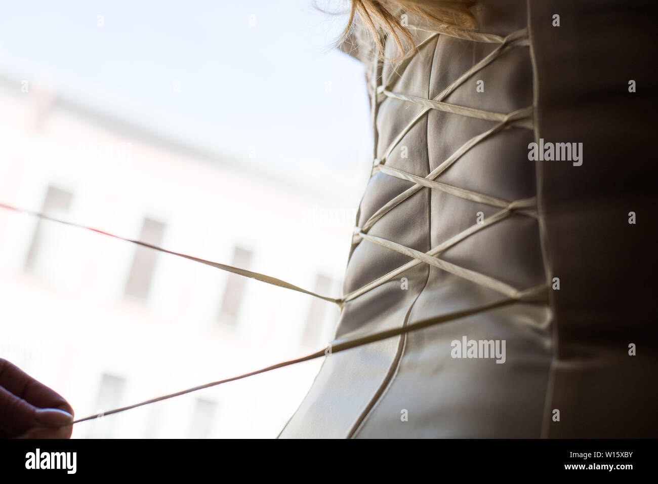 Bride from the back. Lacing the wedding dress Stock Photo - Alamy
