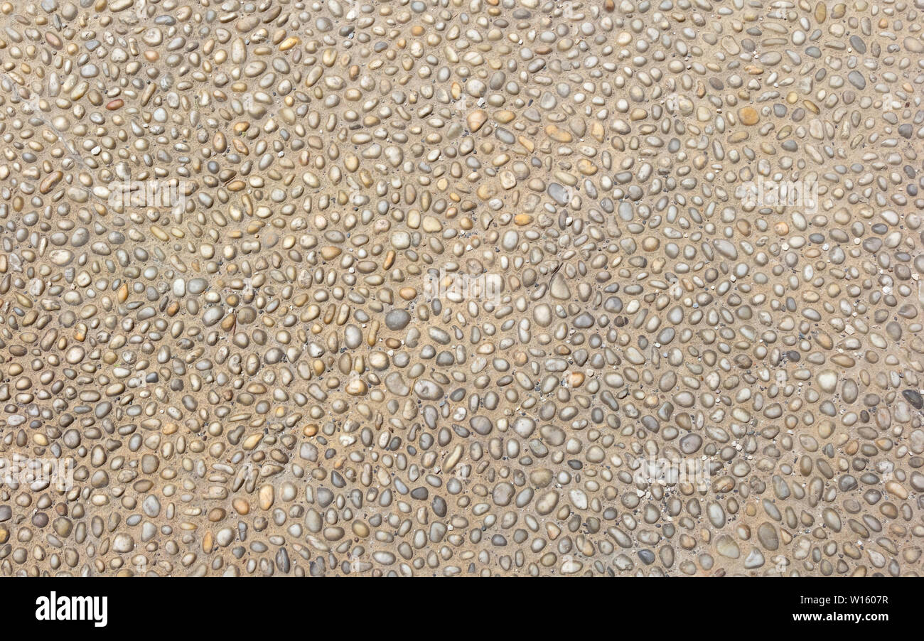 Small rounded stones in the ground Stock Photo - Alamy