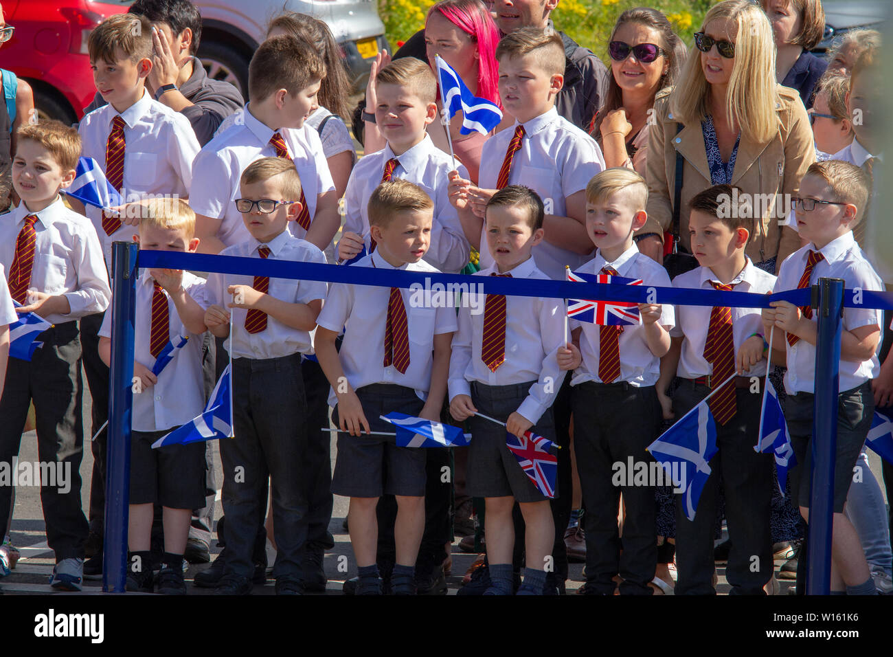 Schoolchildren with Scottish and British flags lined the street. HM The ...