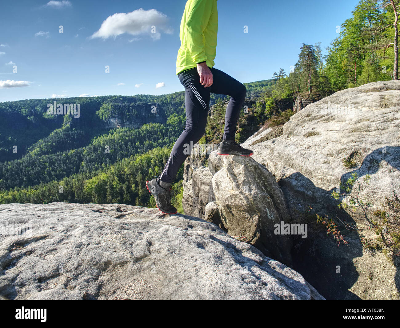 Fitness man trail runner running to rocky mountain top on cracked rocky ...