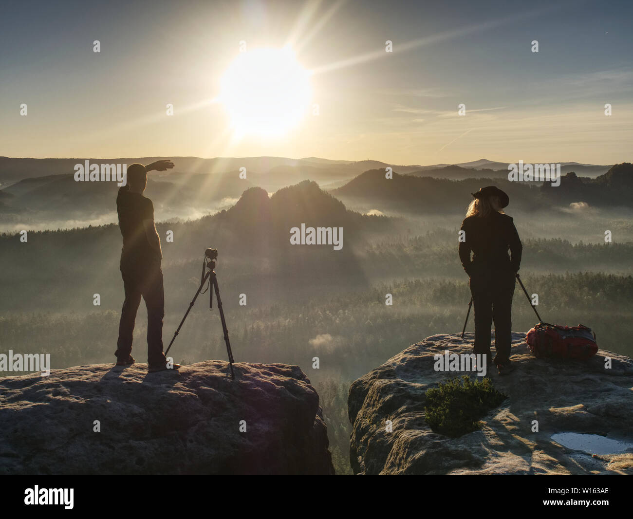 Two hikers taking pictures and talk on top of the mountain. Hikers ...