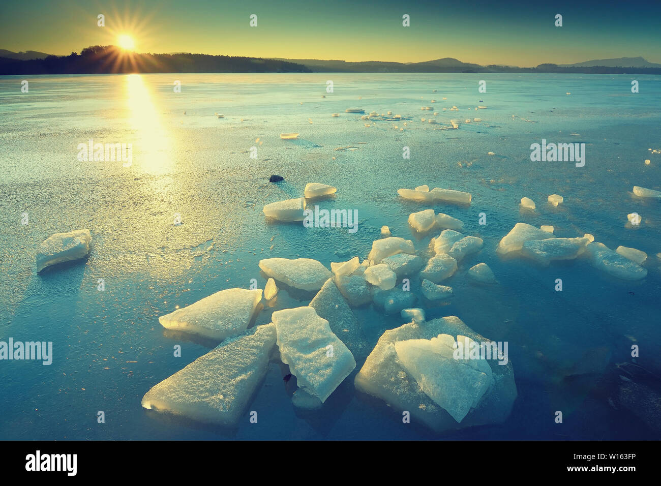 Water and ice edge. Ice with purple brilliant color covered the dark ...