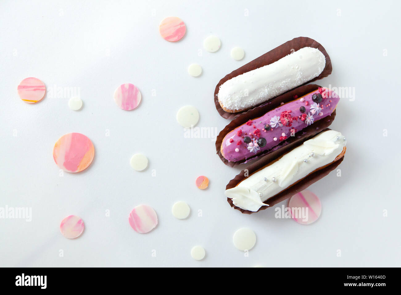 A set of three eclairs with different fillings and design isolate on a ...