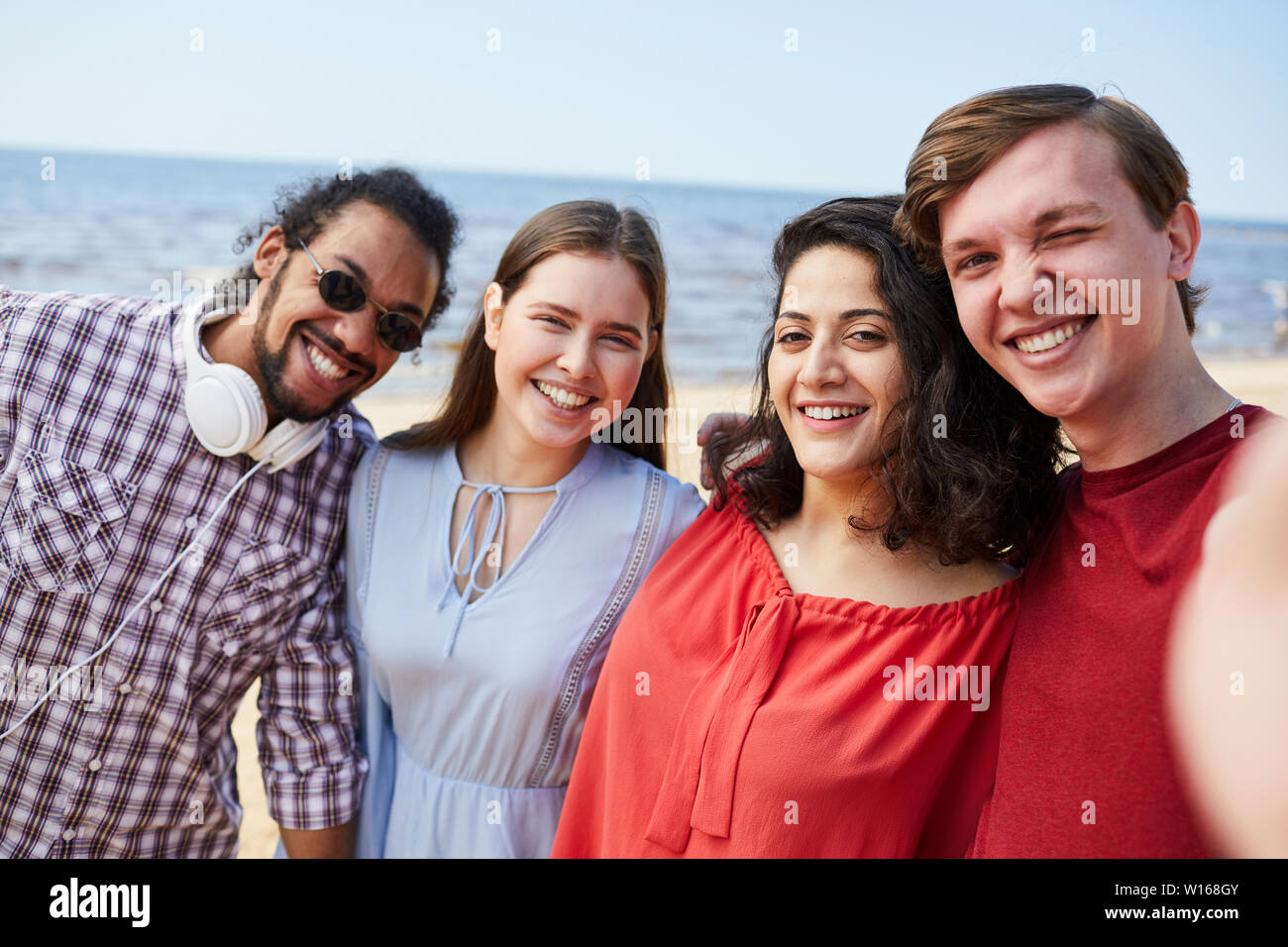 Group of happy young people posing at beach enjoying Summer, copy space ...