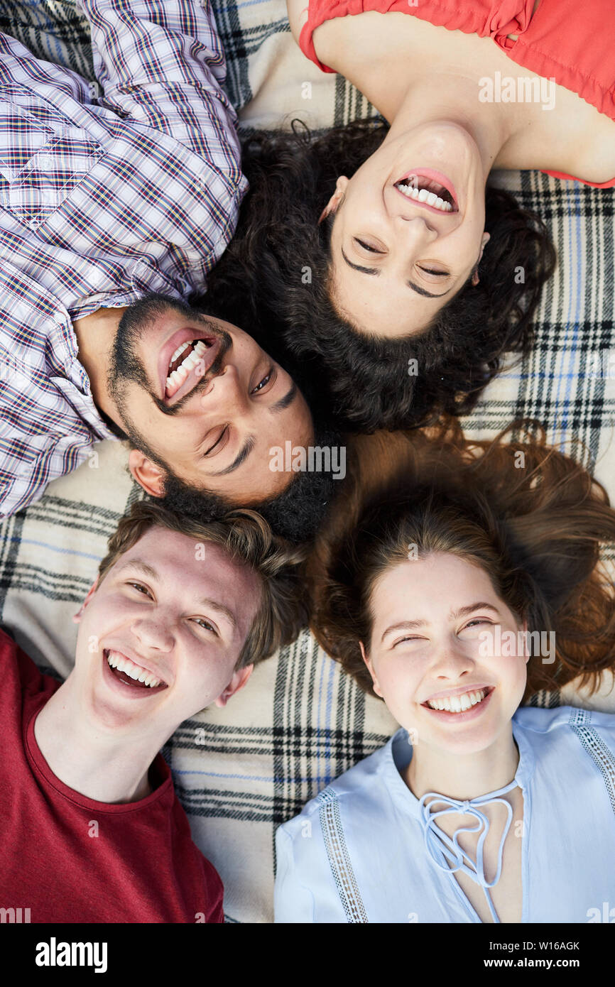 Top view portrait of group of friends lying in circle on picnic blanket ...