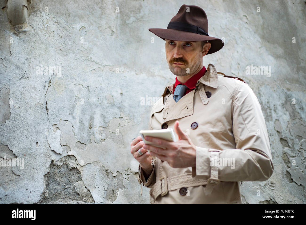 Detective taking notes in a ghetto Stock Photo - Alamy