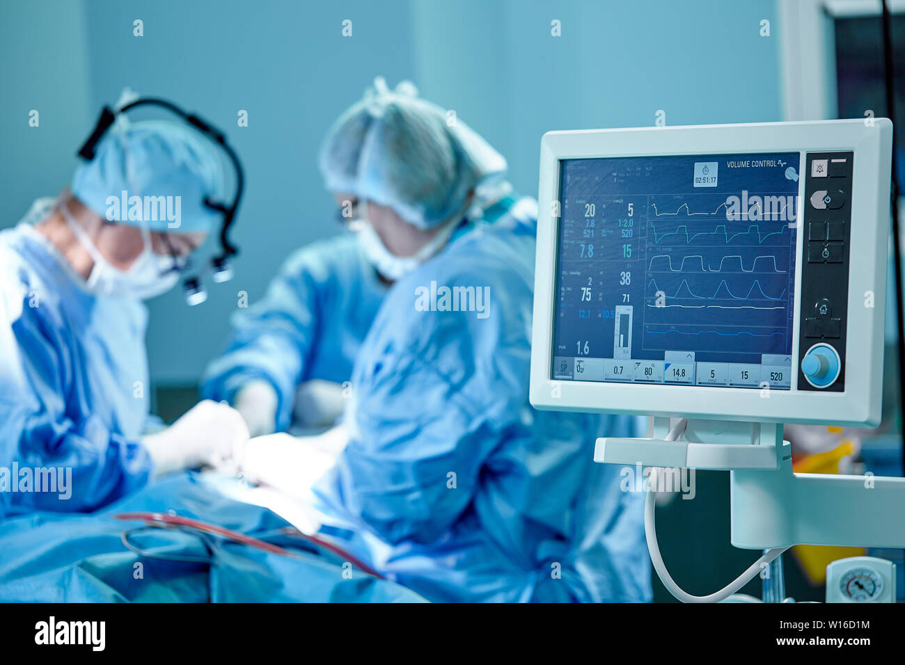 A surgeon's team in uniform performs an operation on a patient at a ...