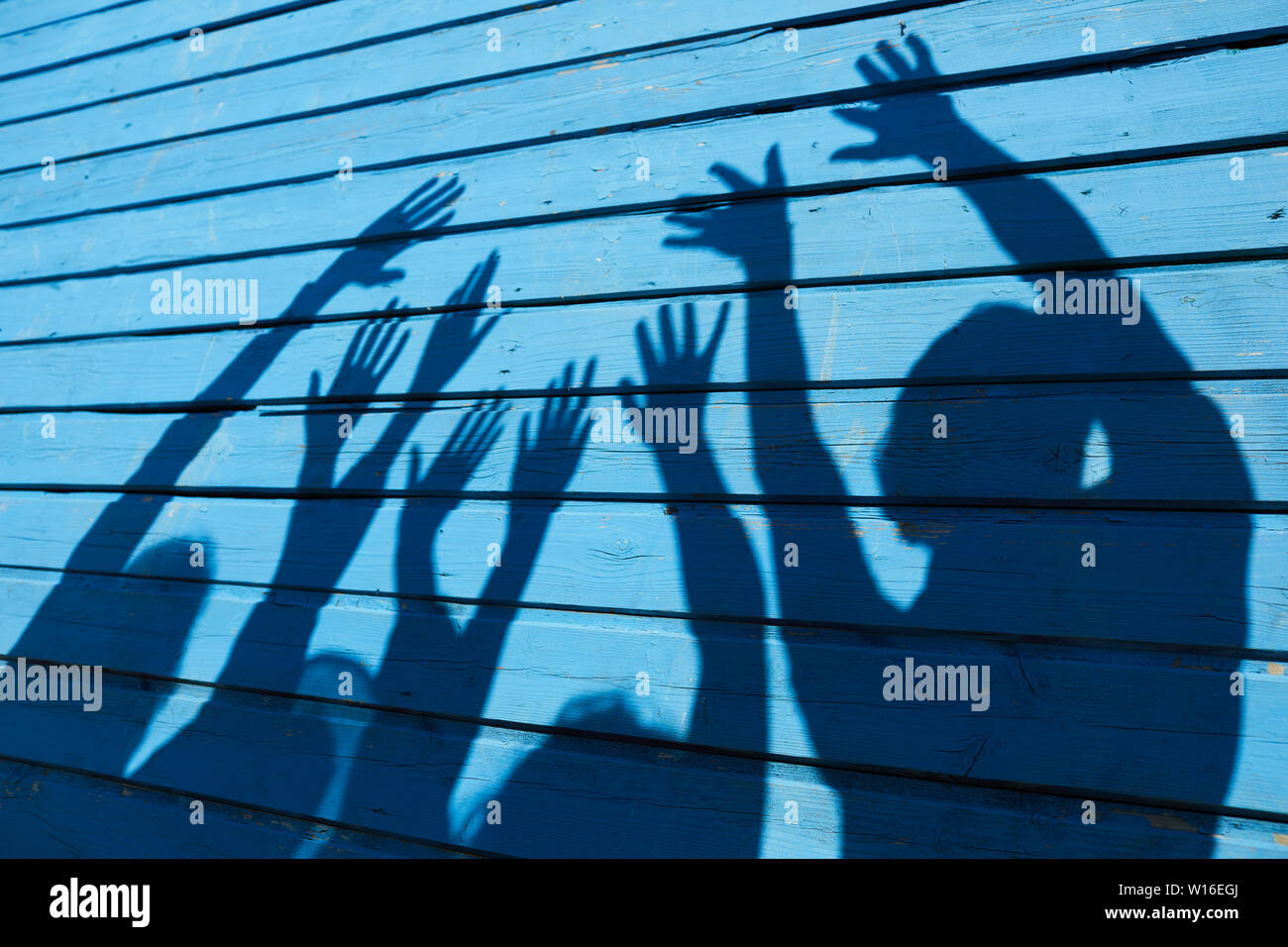 Shadow silhouette of happy young people having fun in Summer on blue ...