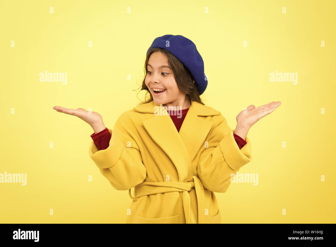 Child promoting something yellow background copy space. Place for ad ...