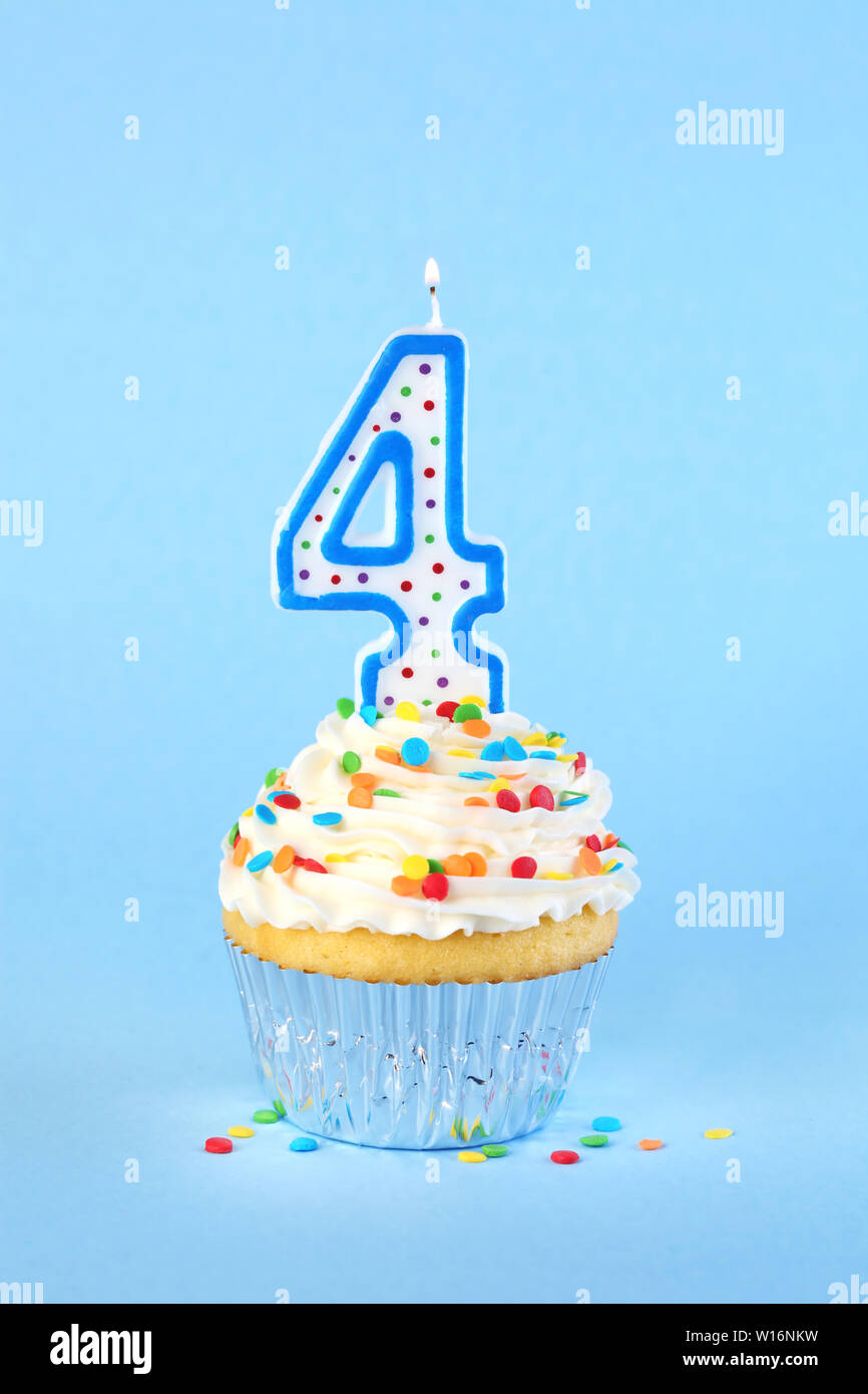 Iced birthday cupcake with with lit number 4 candle and sprinkles Stock ...
