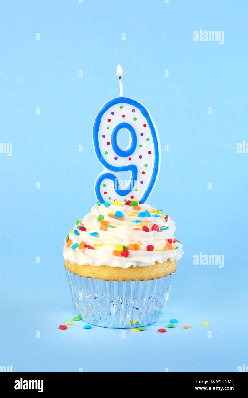 Iced birthday cupcake with with lit number 9 candle and sprinkles Stock ...