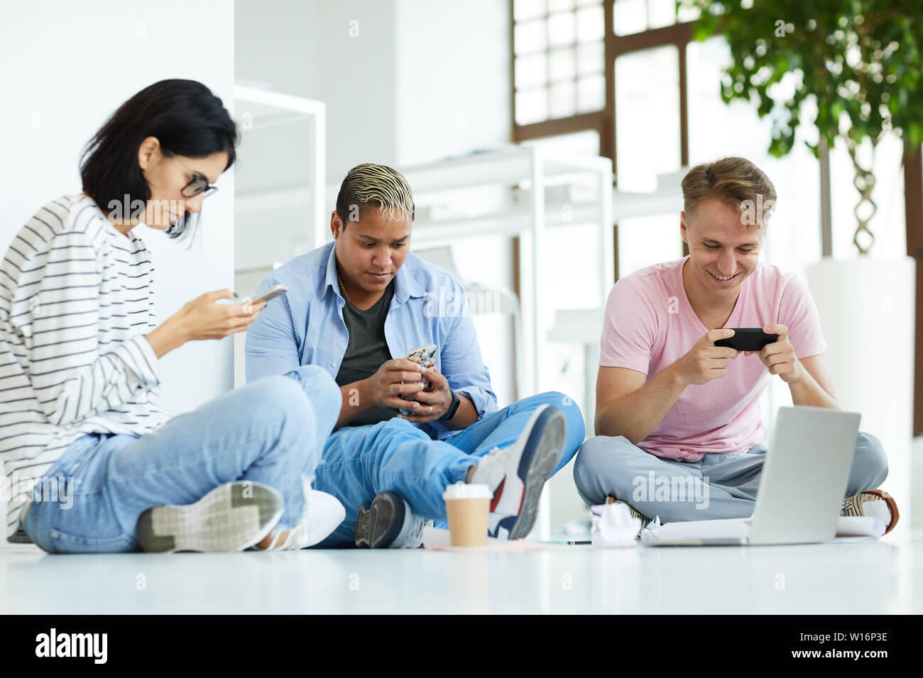 Group of technology-addicted students in casual clothing sitting in ...