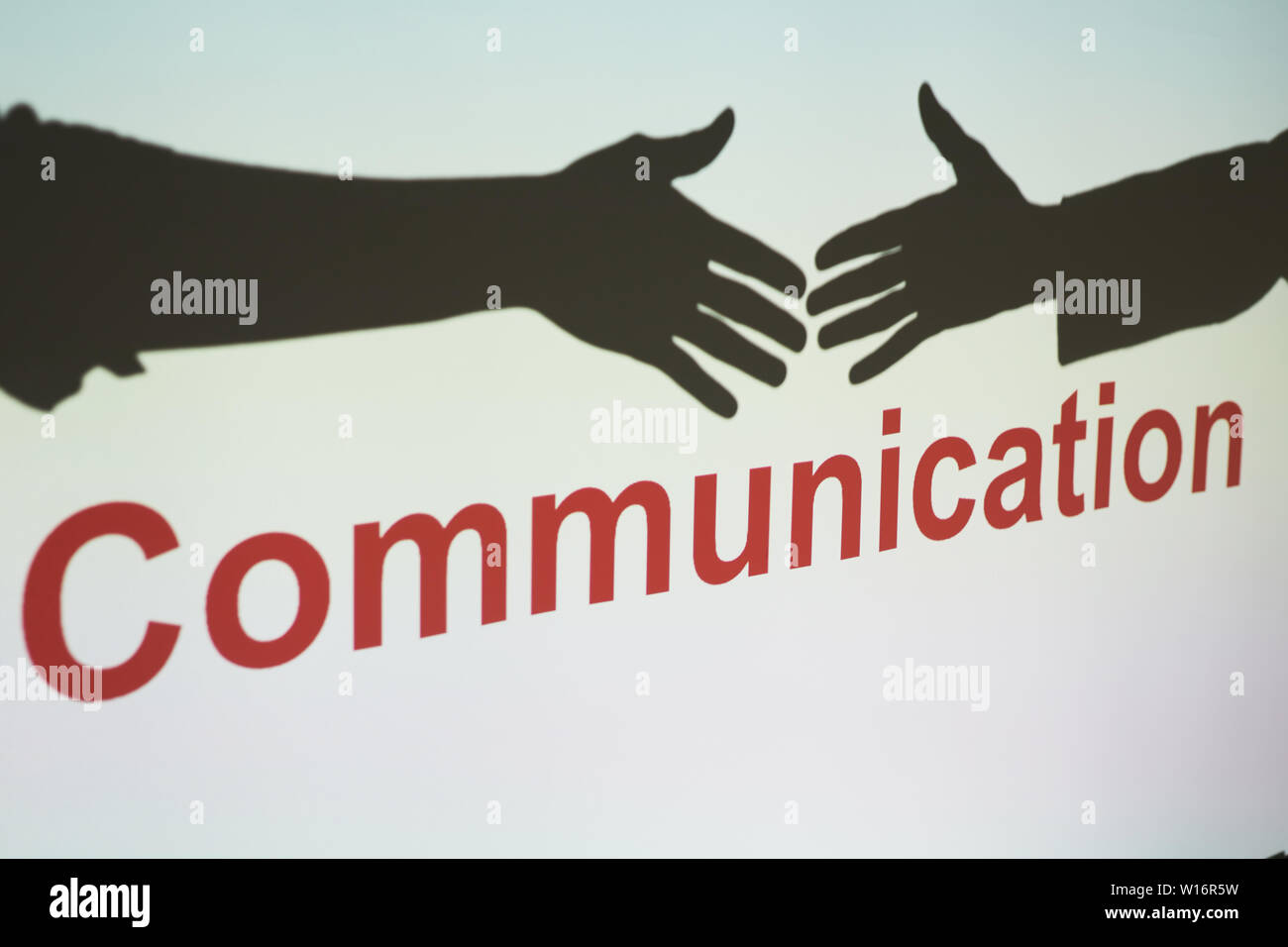Projection screen with word communication and silhouette of hand ...