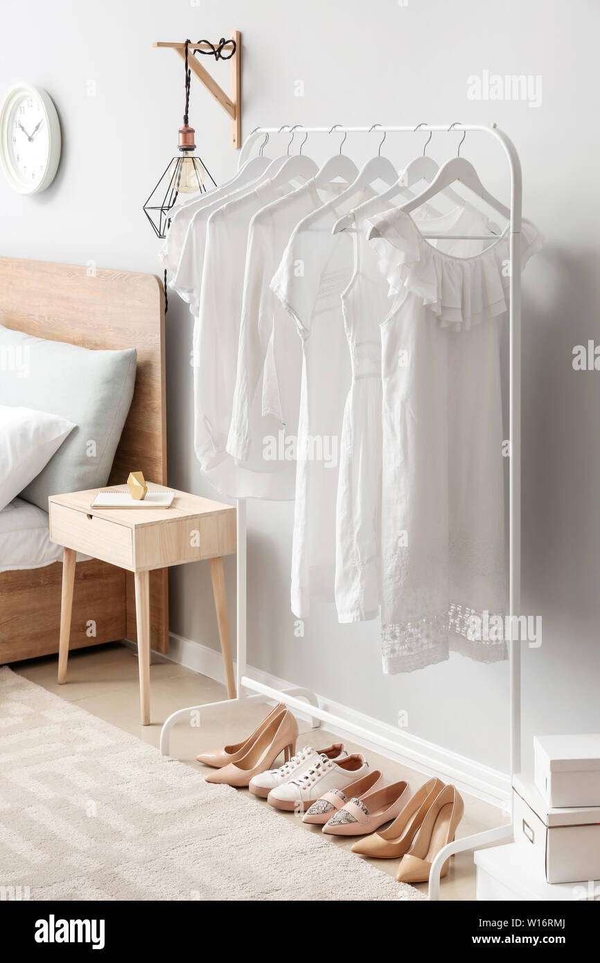 Rack with clean clothes in room Stock Photo - Alamy