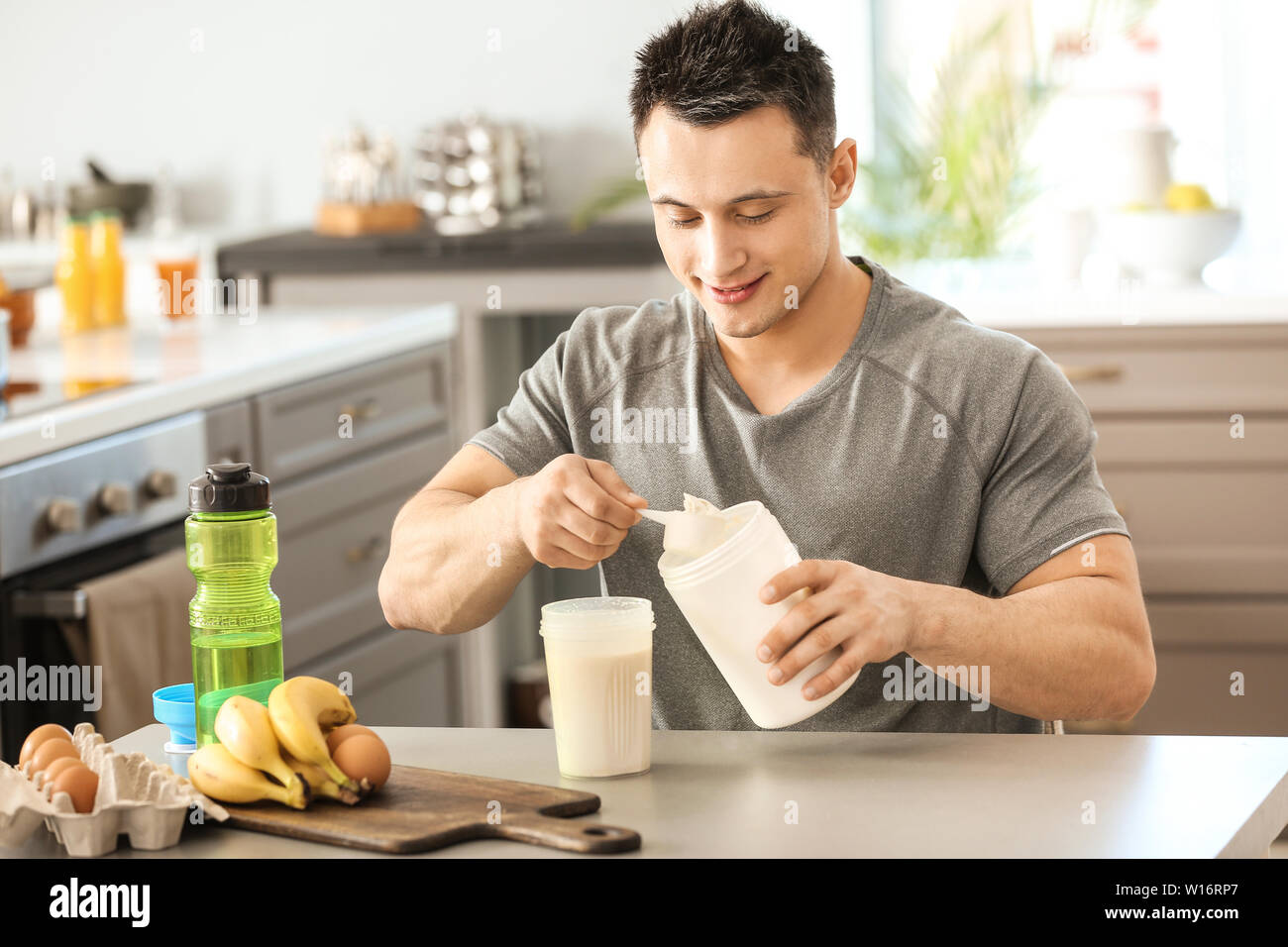 Sporty man making protein shake at home Stock Photo - Alamy