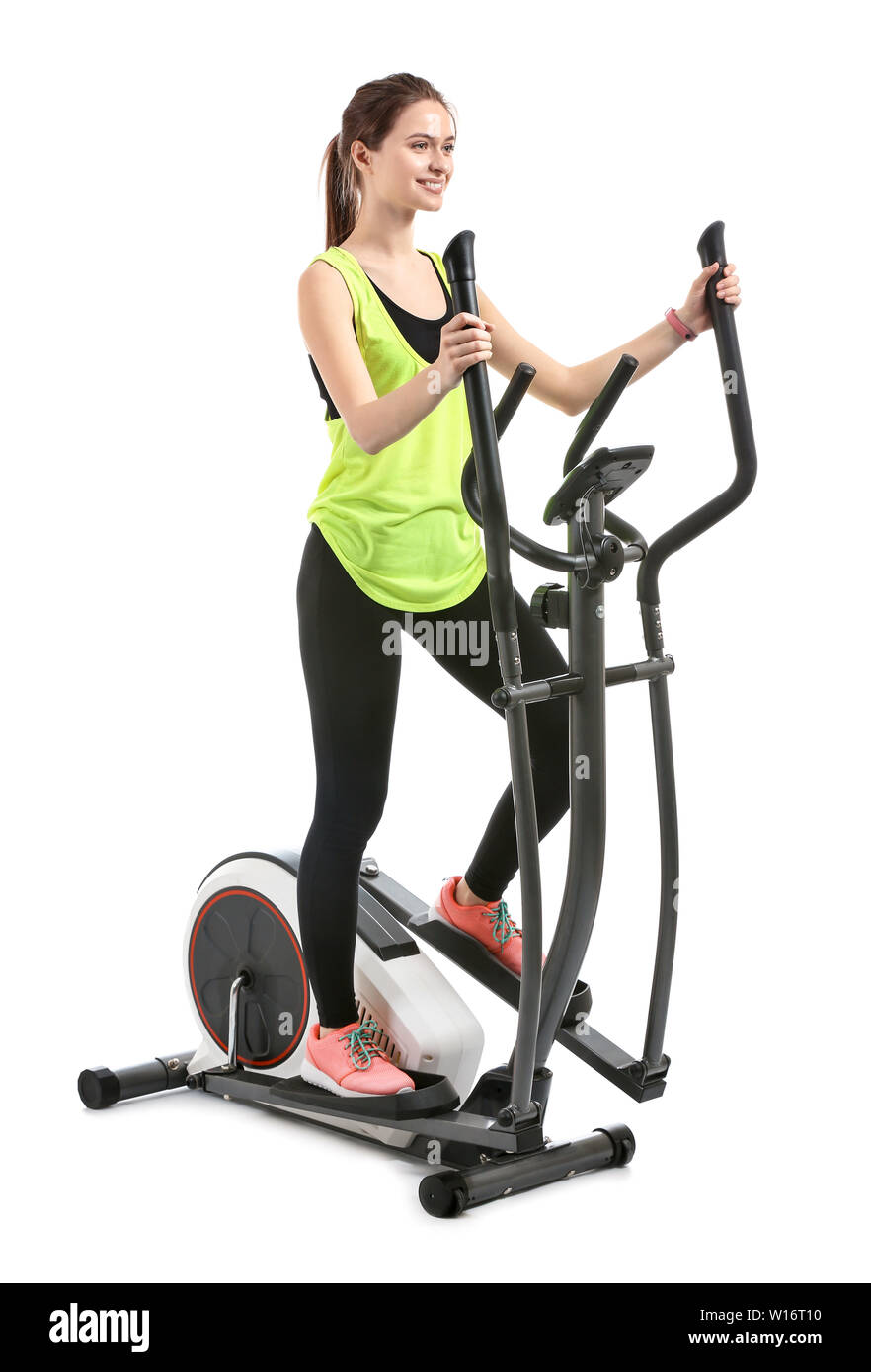 Sporty young woman training on machine against white background Stock ...