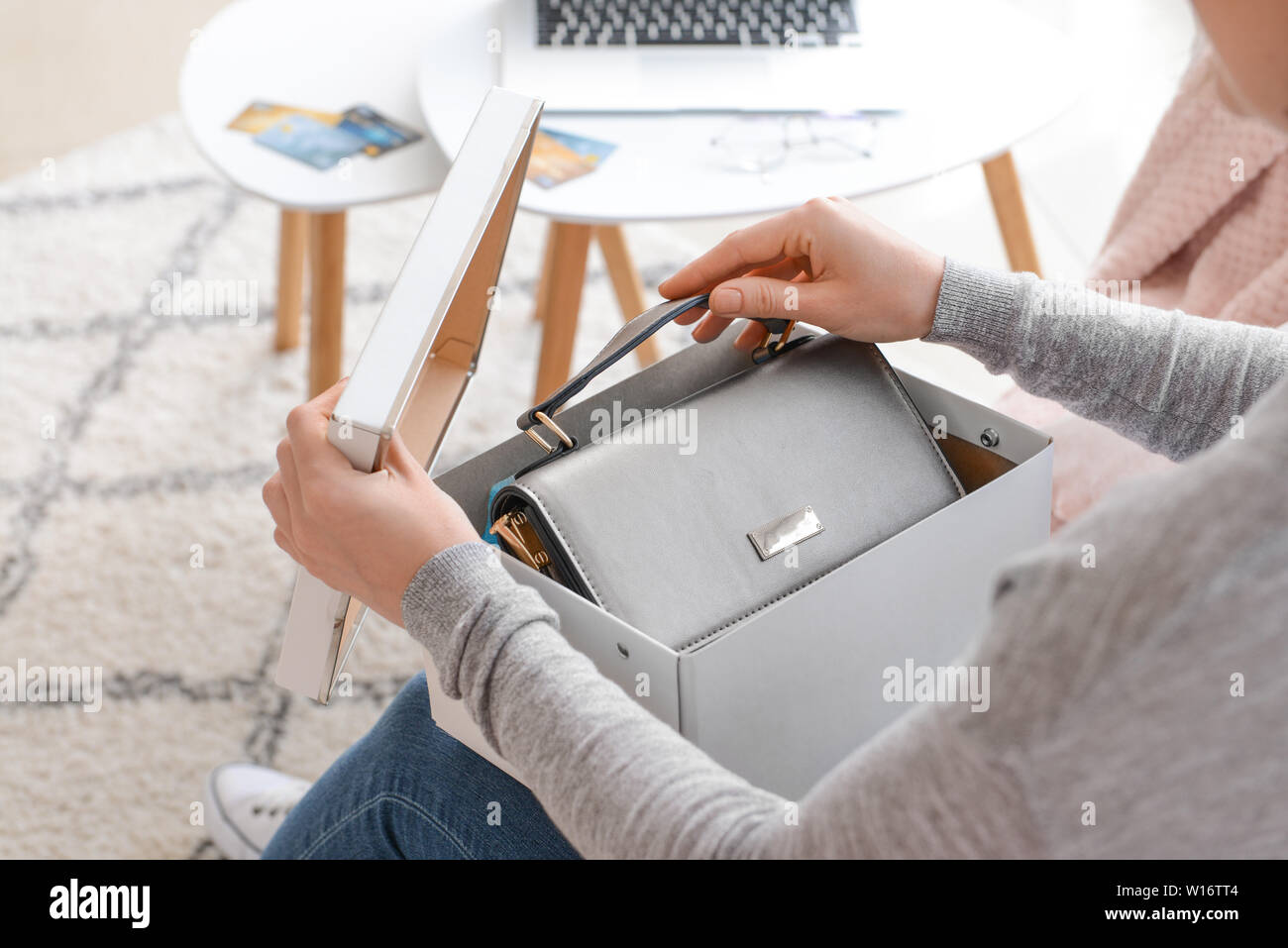 Young woman opening parcel with new purchase at home Stock Photo - Alamy