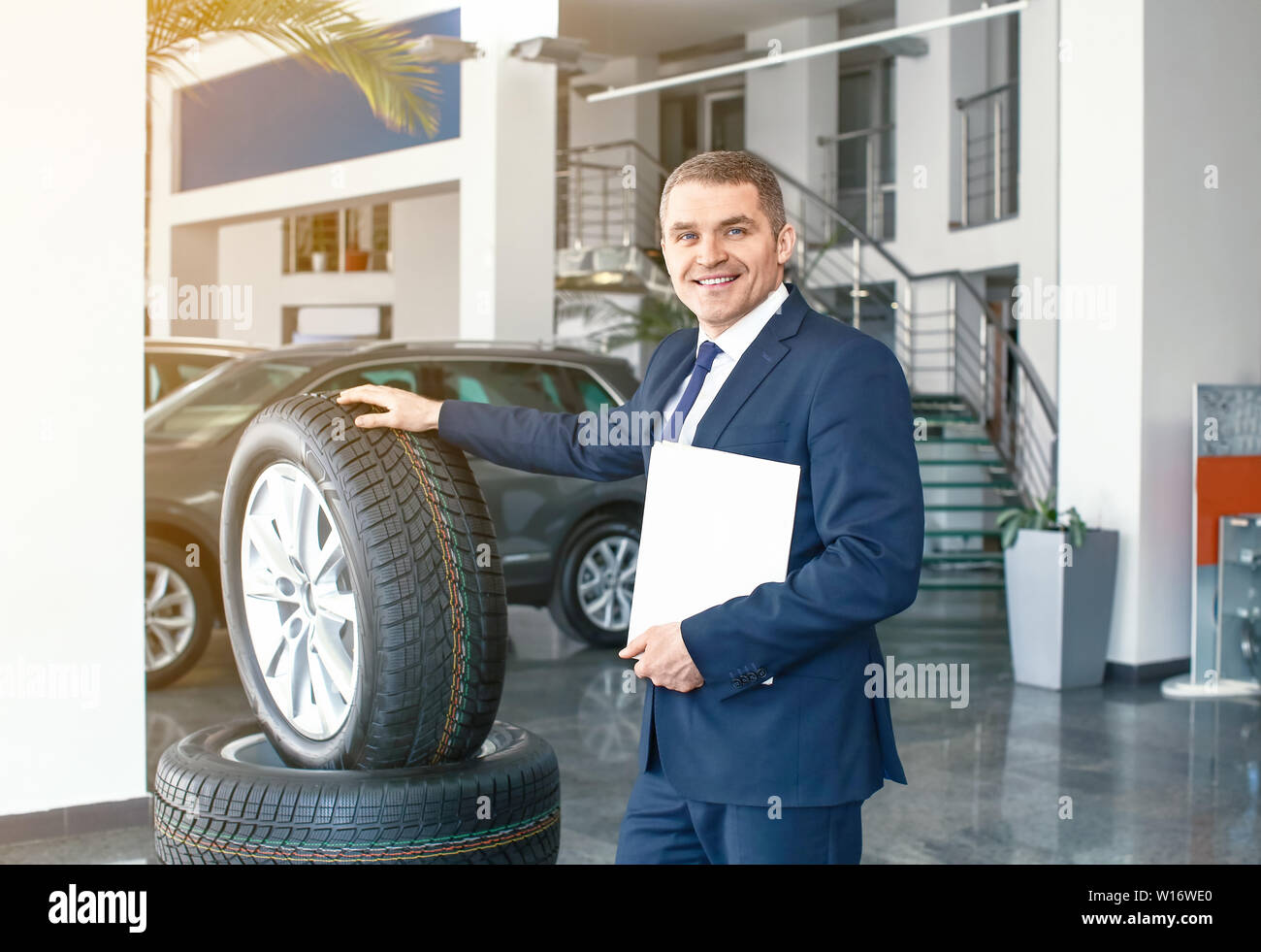 x Salesman in modern car showroom Stock Photo - Alamy