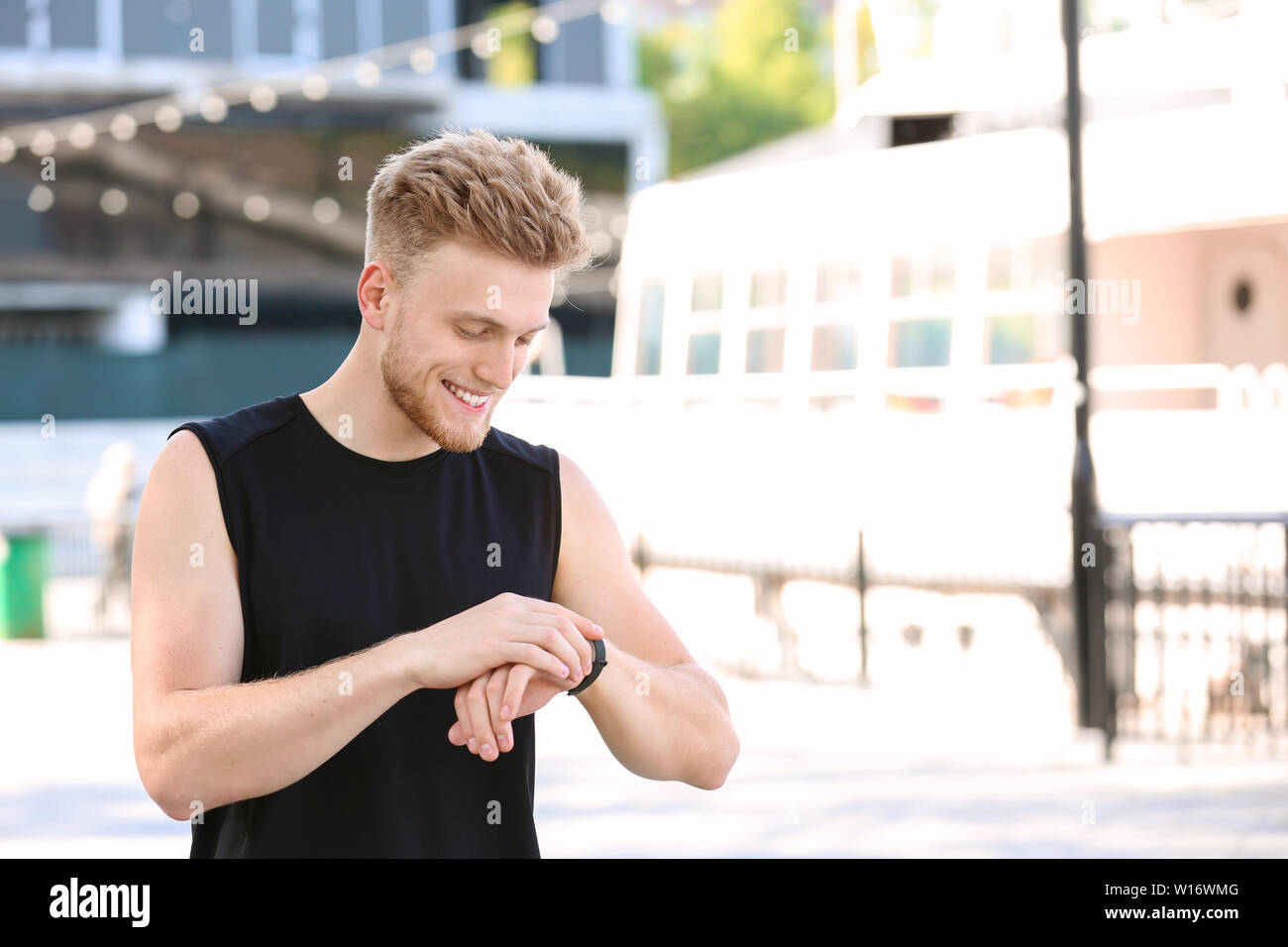 Sporty young man checking his pulse outdoors Stock Photo - Alamy