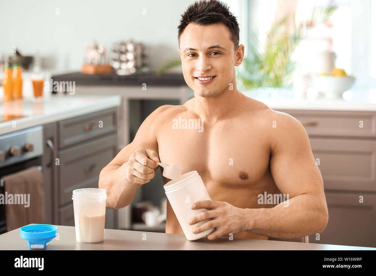 Sporty man making protein shake at home Stock Photo - Alamy