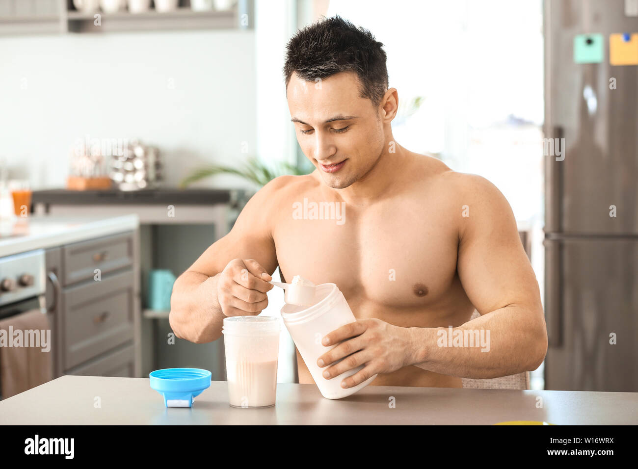 Sporty man making protein shake at home Stock Photo - Alamy