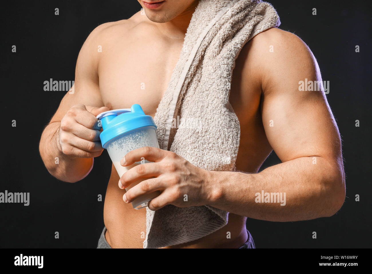 Sporty man with protein shake on dark background Stock Photo - Alamy
