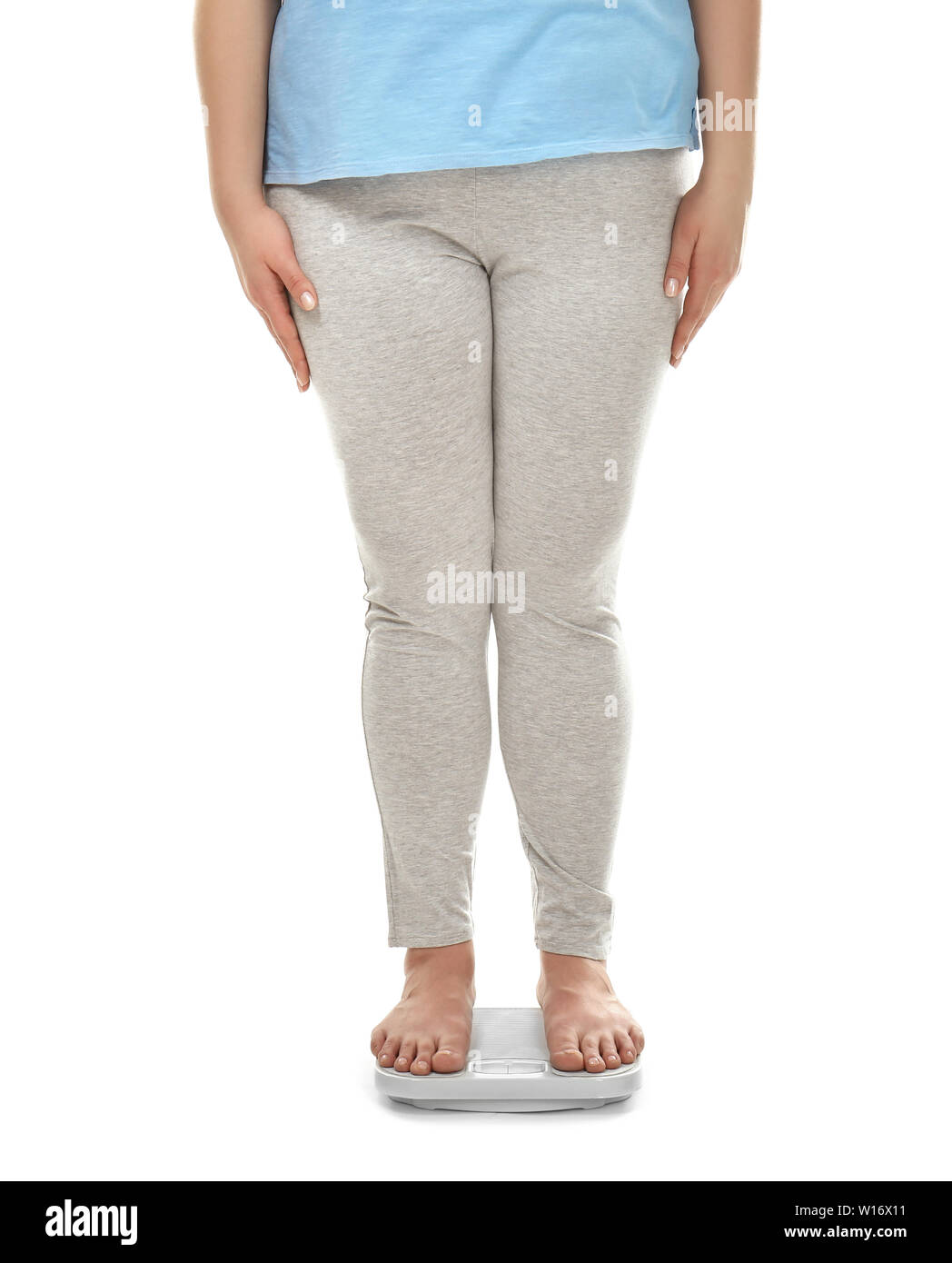 Overweight woman on scales against white background Stock Photo - Alamy