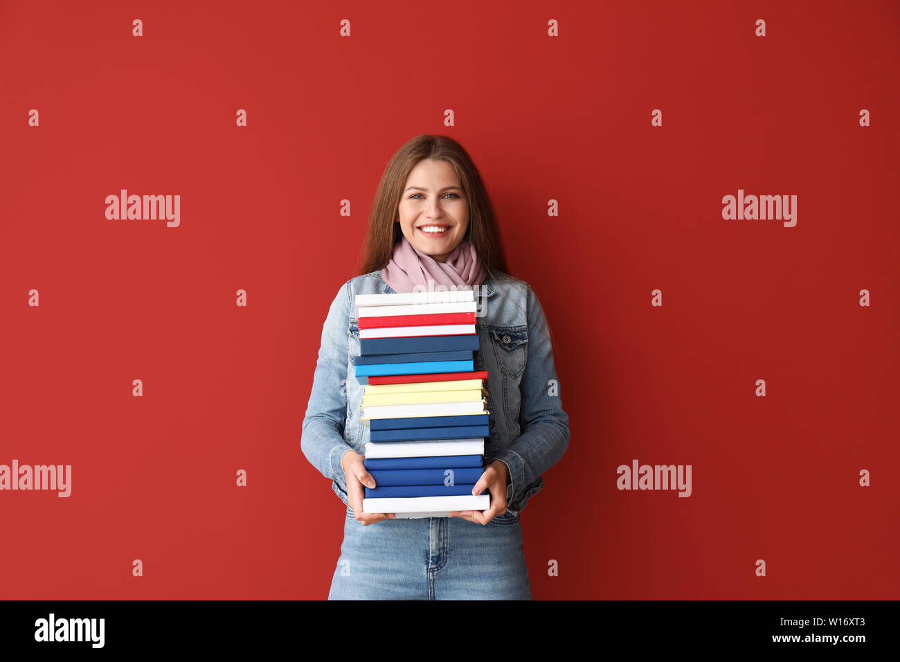 Beautiful young woman with books on color background Stock Photo - Alamy