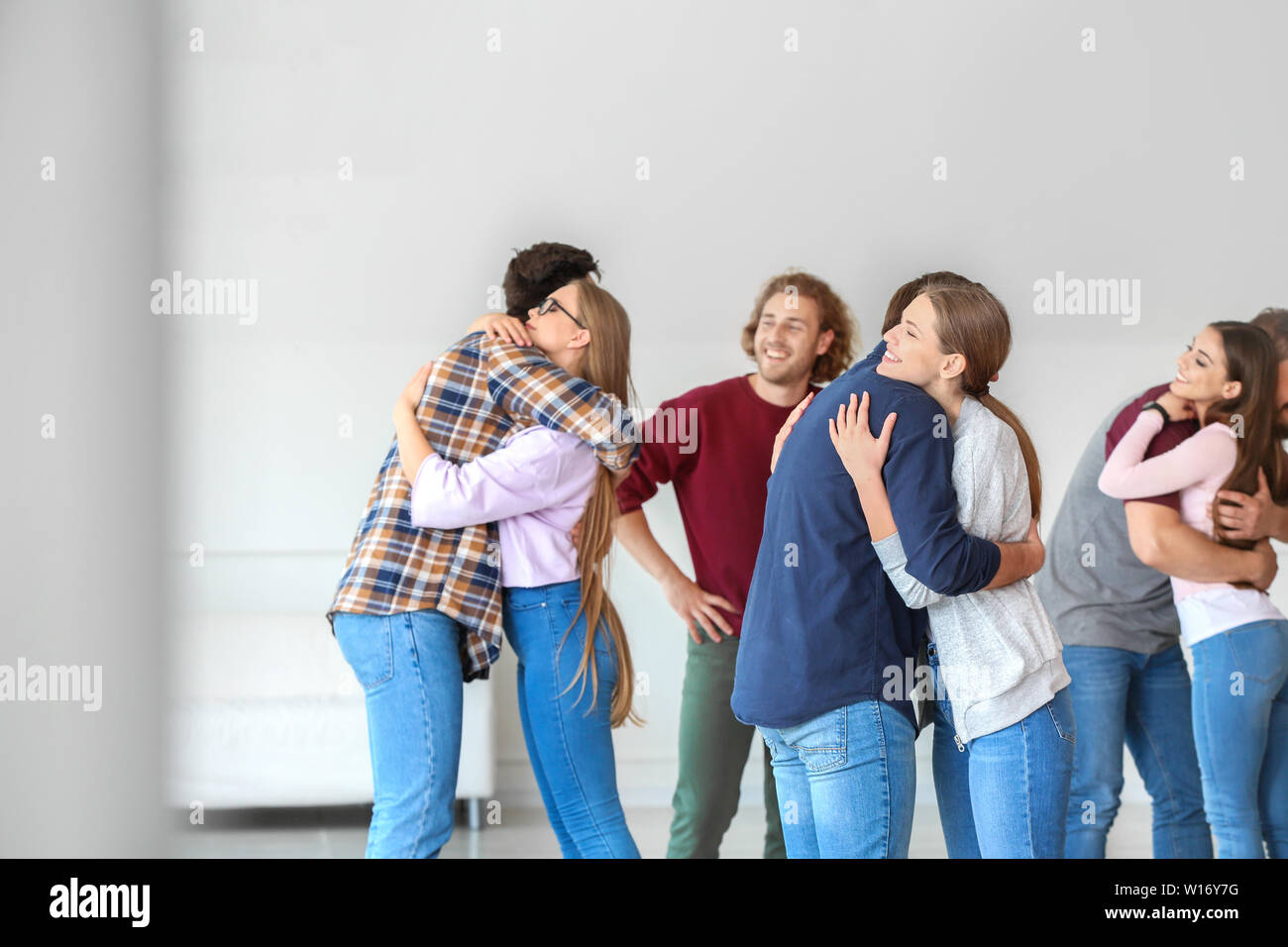 Hugging young people at group therapy session Stock Photo - Alamy