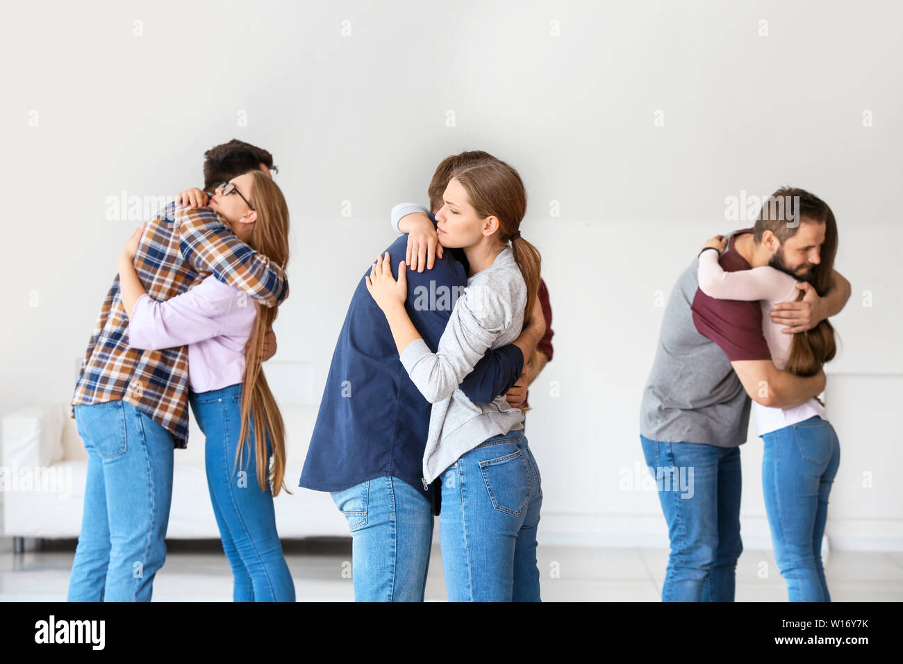 Hugging young people at group therapy session Stock Photo - Alamy