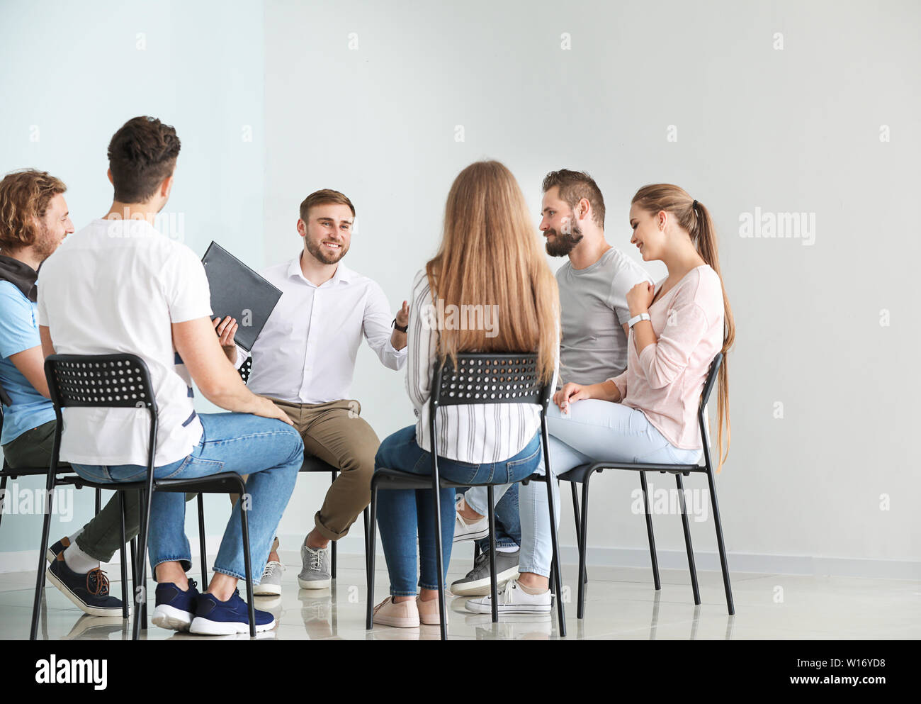 Young people with psychologist at group therapy session Stock Photo - Alamy