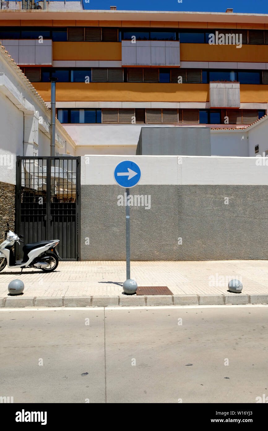 One way traffic flow sign on a post at the end of a street in Nerja ...