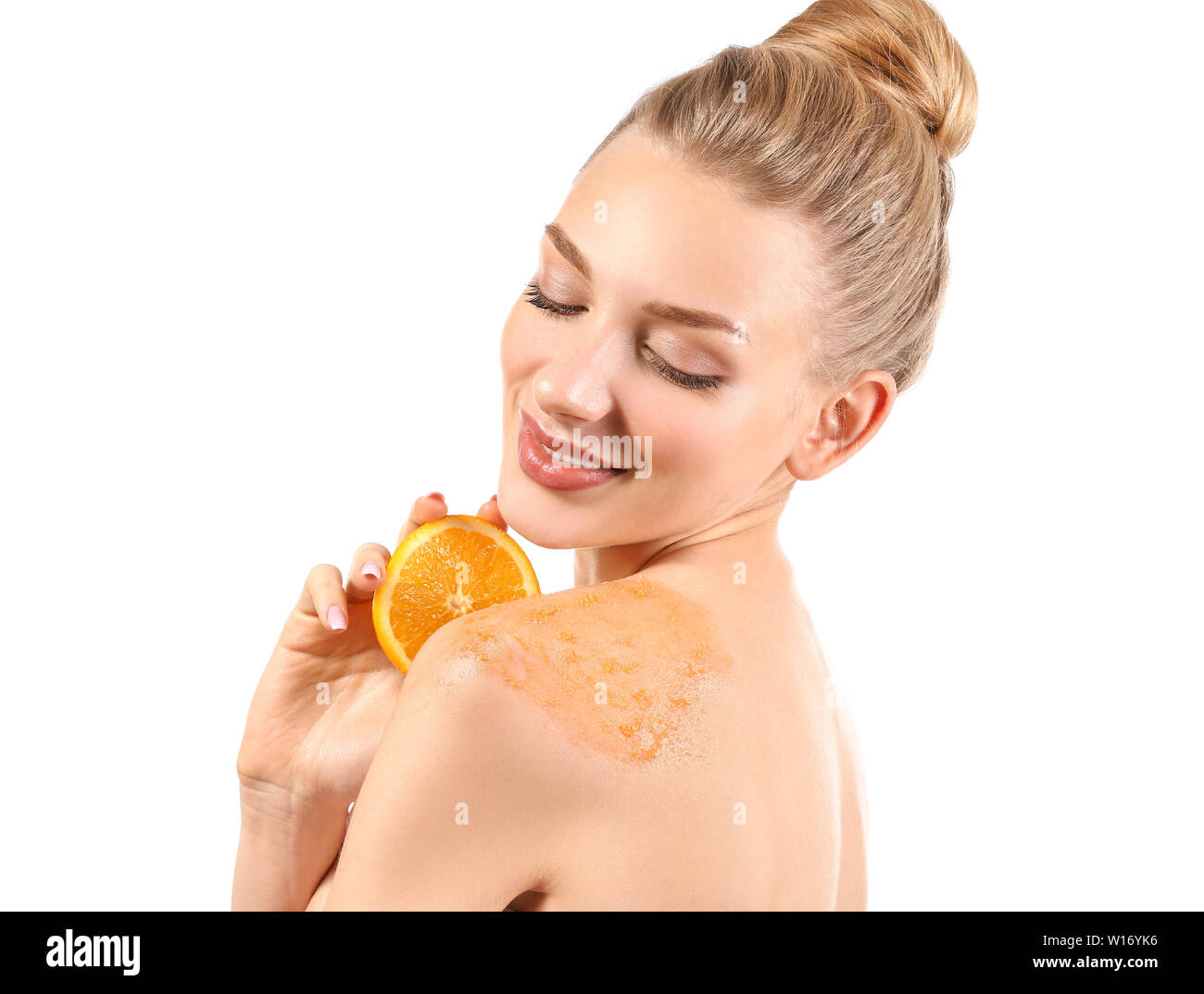 Young woman with orange body scrub on her body against white background ...