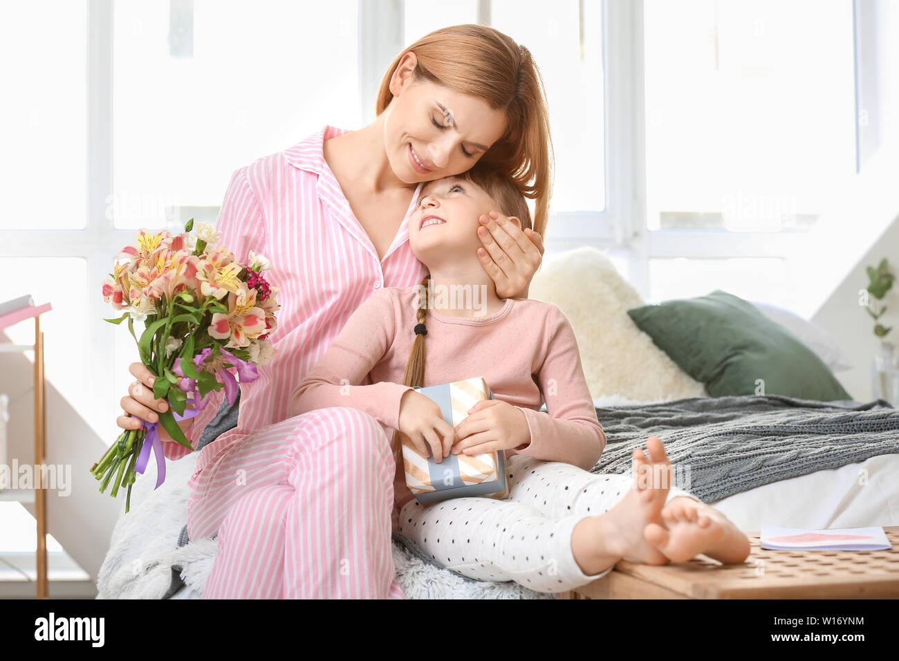 Little girl greeting her mother at home Stock Photo - Alamy